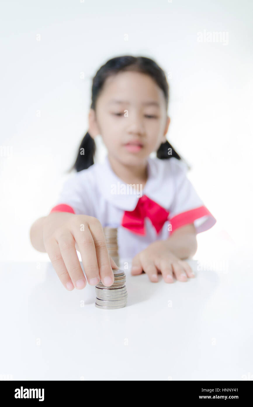 Asian little girl in Thai student uniform stacking coins, Select focus ...