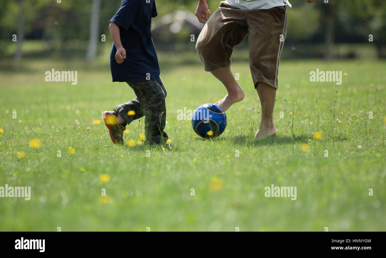 Parent and children playing football Stock Photo - Alamy