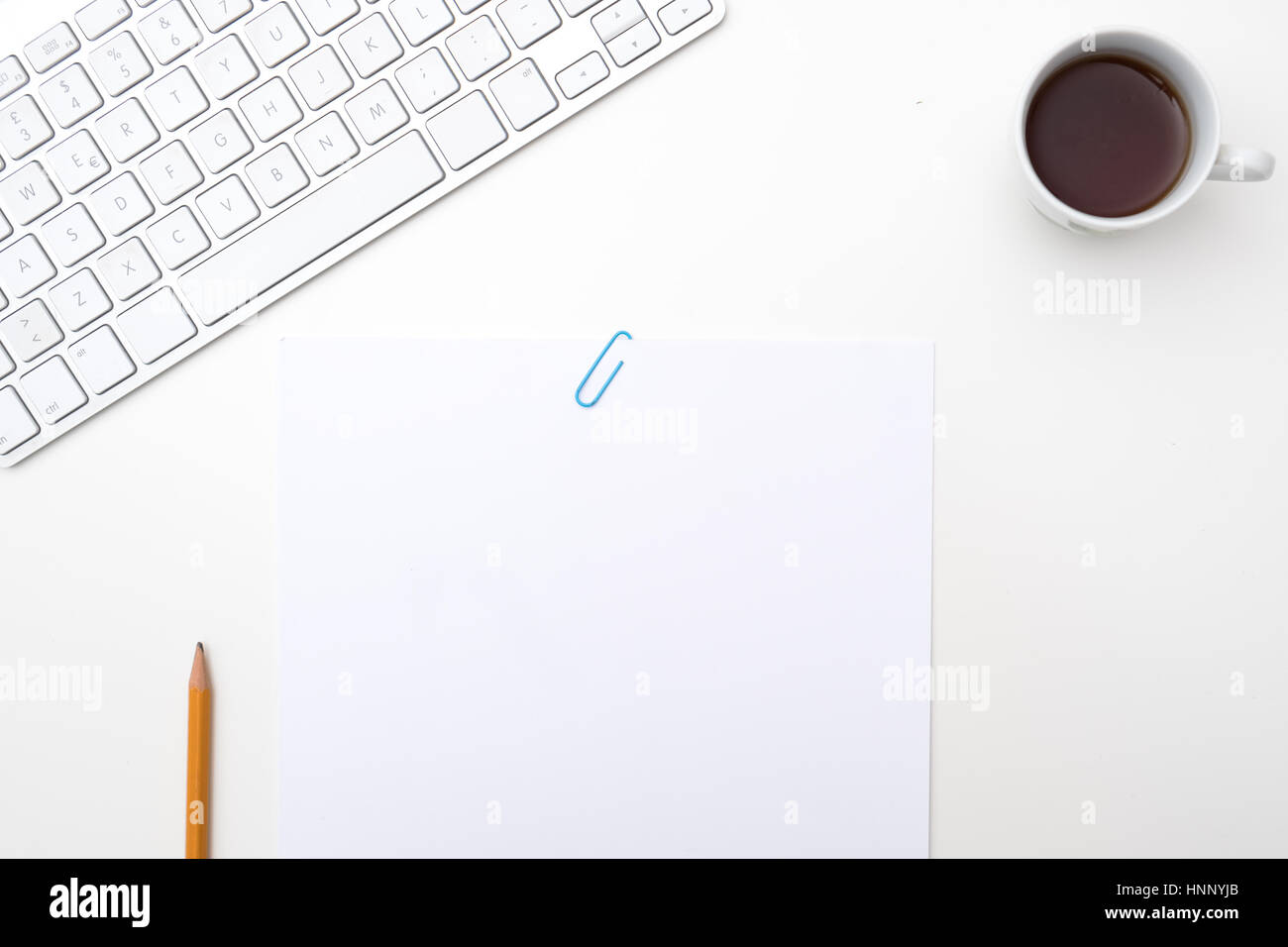 White desk with block note pencil and colored paperclip Stock Photo - Alamy