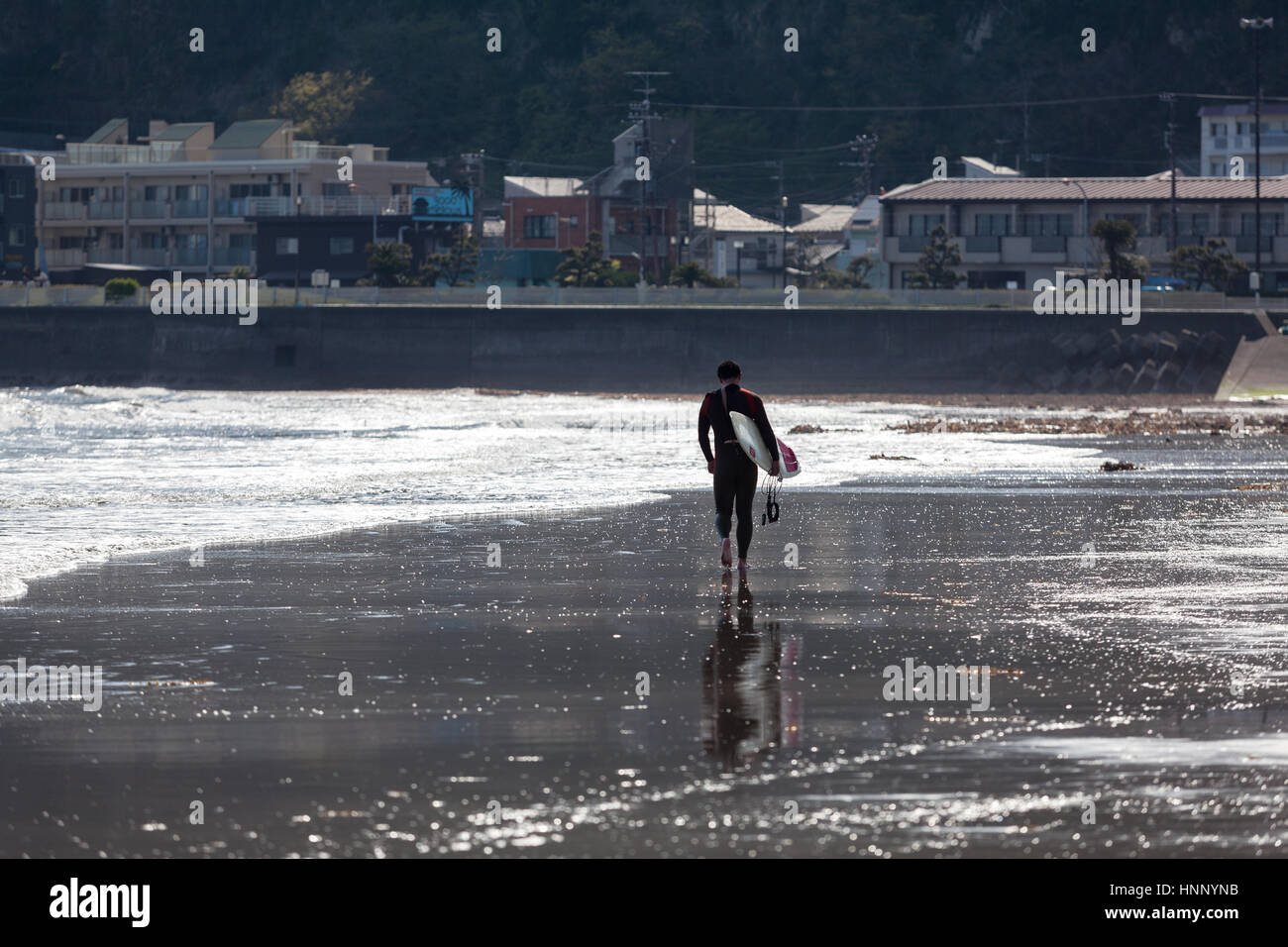 KAMAKURA, JAPAN - CIRCA APR, 2013: Japanese man a surfer steps on low ...