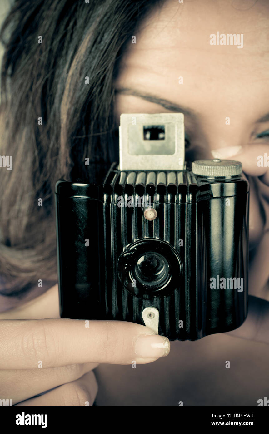 Female latina photographer looking through the viewfinder of a vintage ...