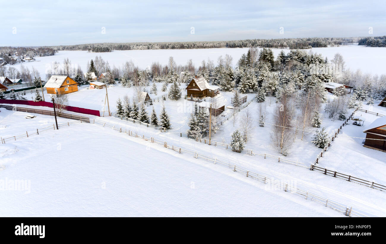 Aerial view over wintry remote Russia village with several farmsteads ...