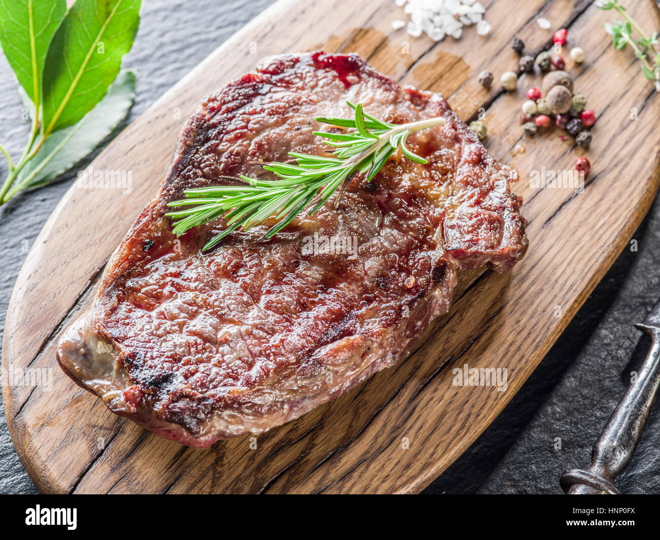 Medium Ribeye steak with spices on the wooden tray Stock Photo - Alamy