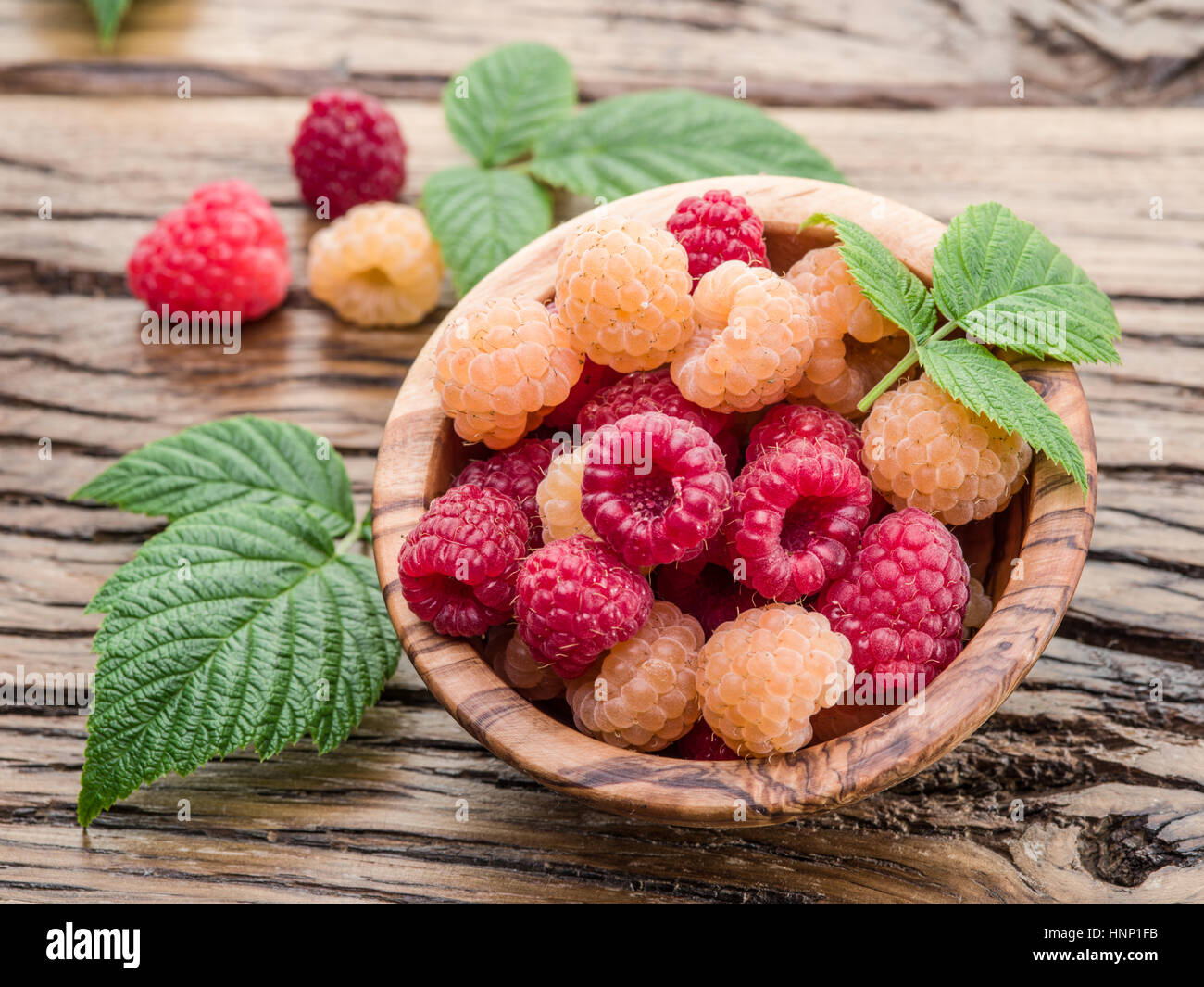Raspberries in the wooden bowl on the table Stock Photo - Alamy