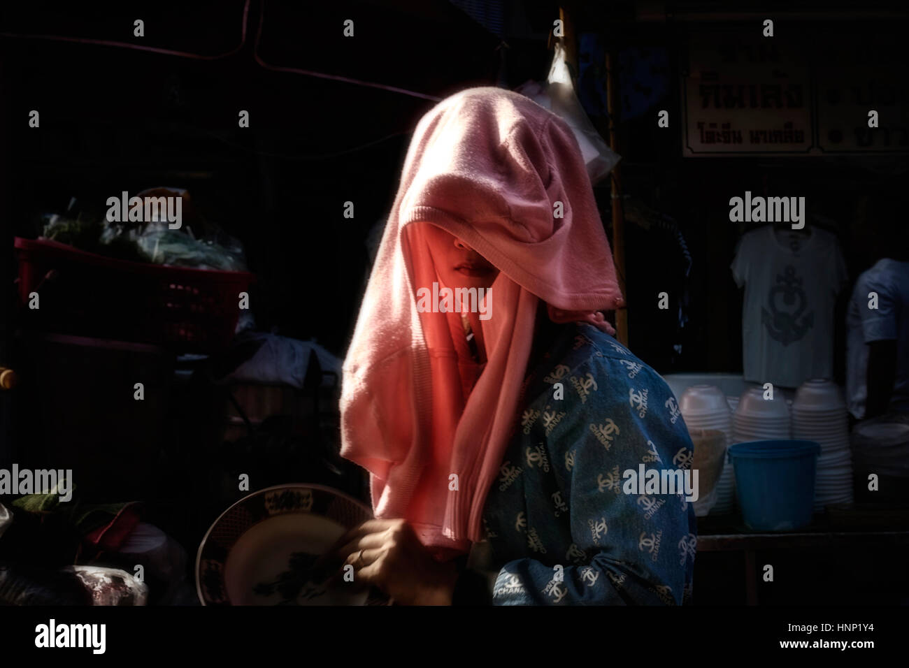 Thailand woman adapting clothing as a sunshade and face sun protection ...