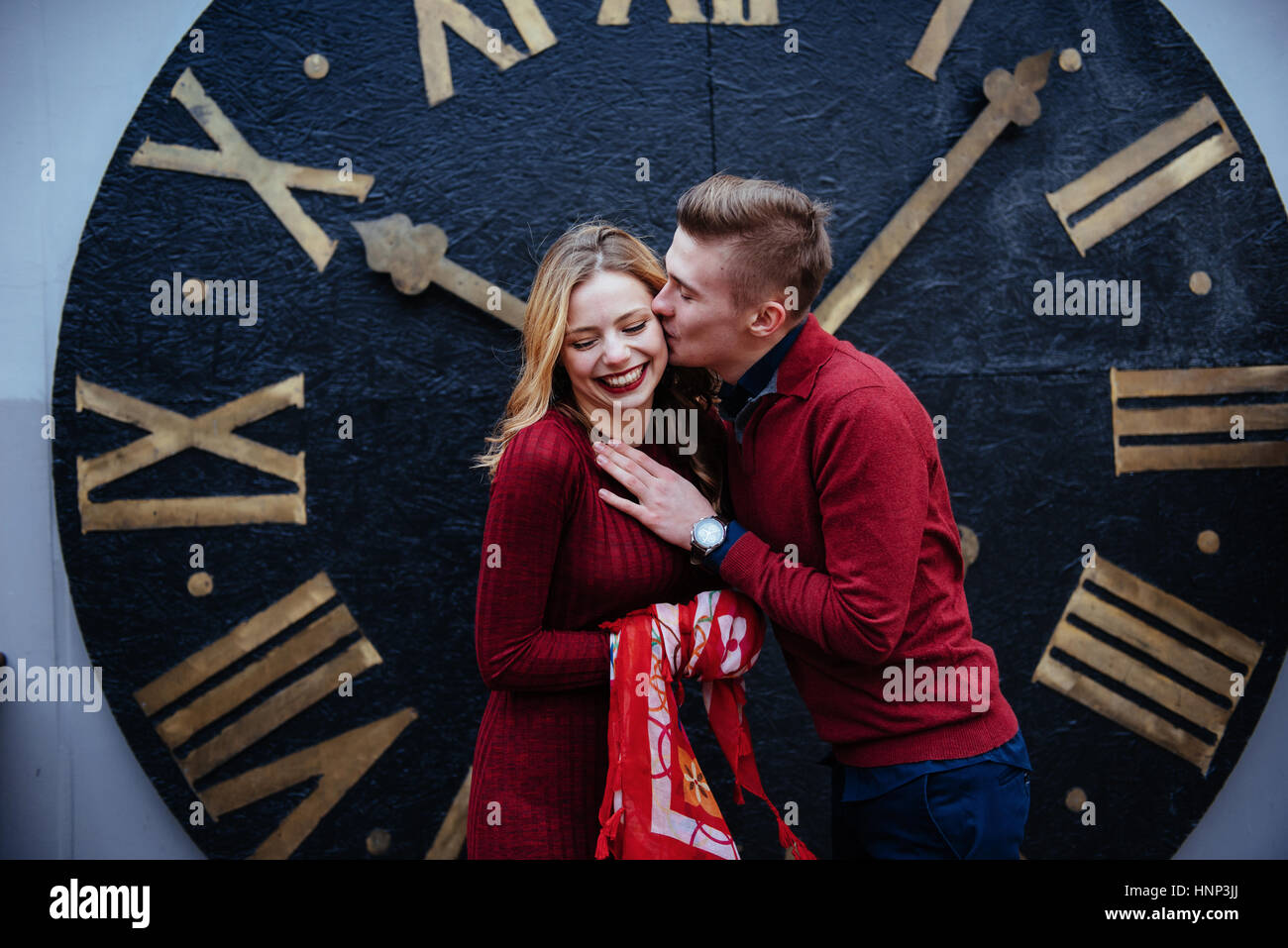 Portrait of beautiful stylish couple standing near the clock. A man ...