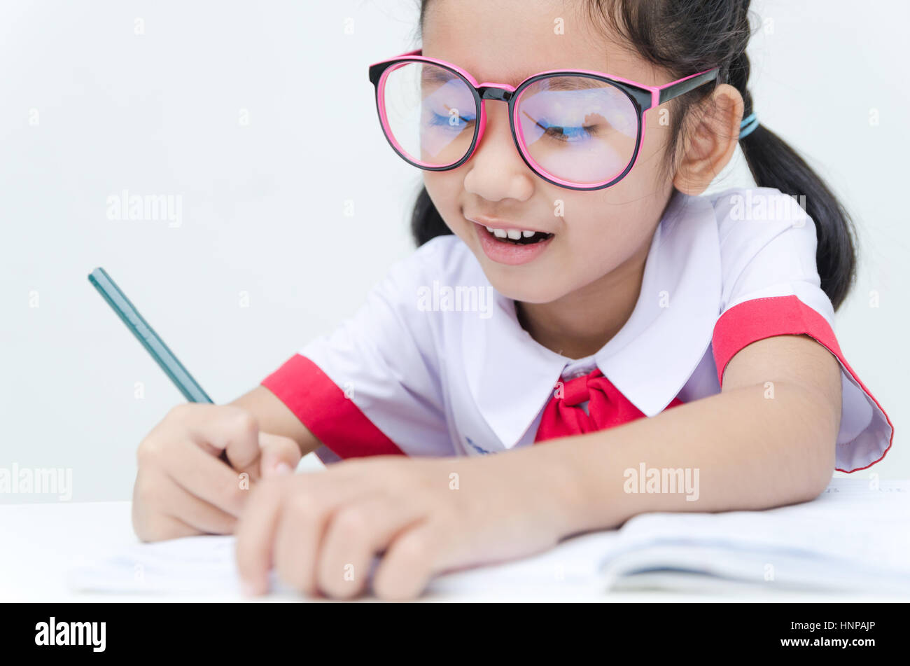 Close up shot of Asian little girl doing homework in Thai Student ...