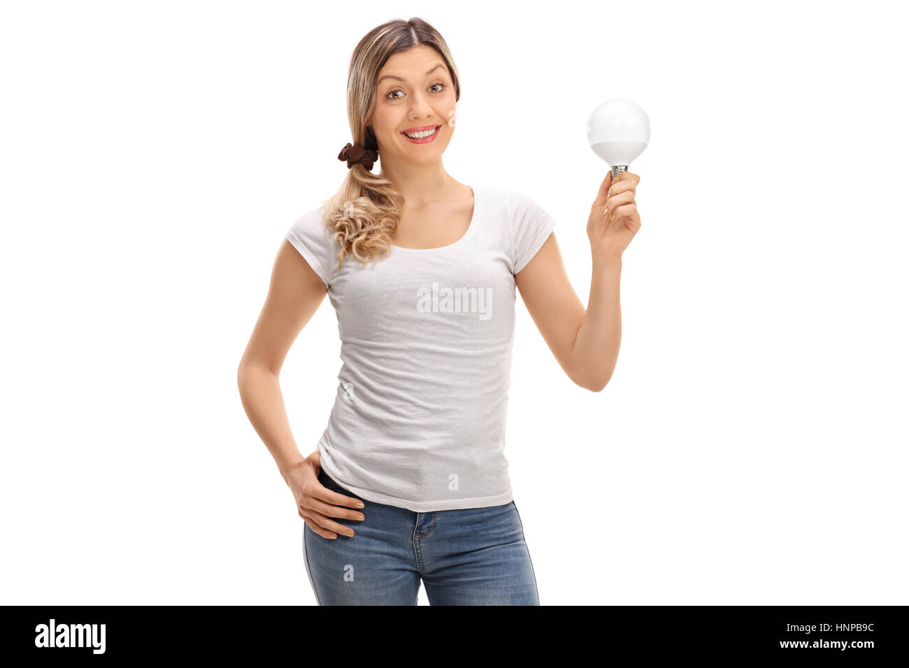 Joyful woman holding a LED light bulb isolated on white background ...