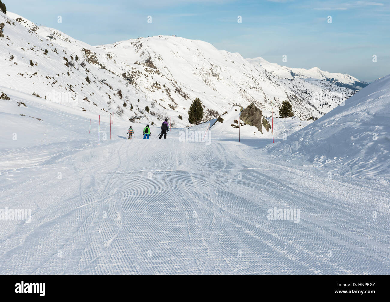Skiers on a ski slope piste in winter alpine mountain resort Stock ...