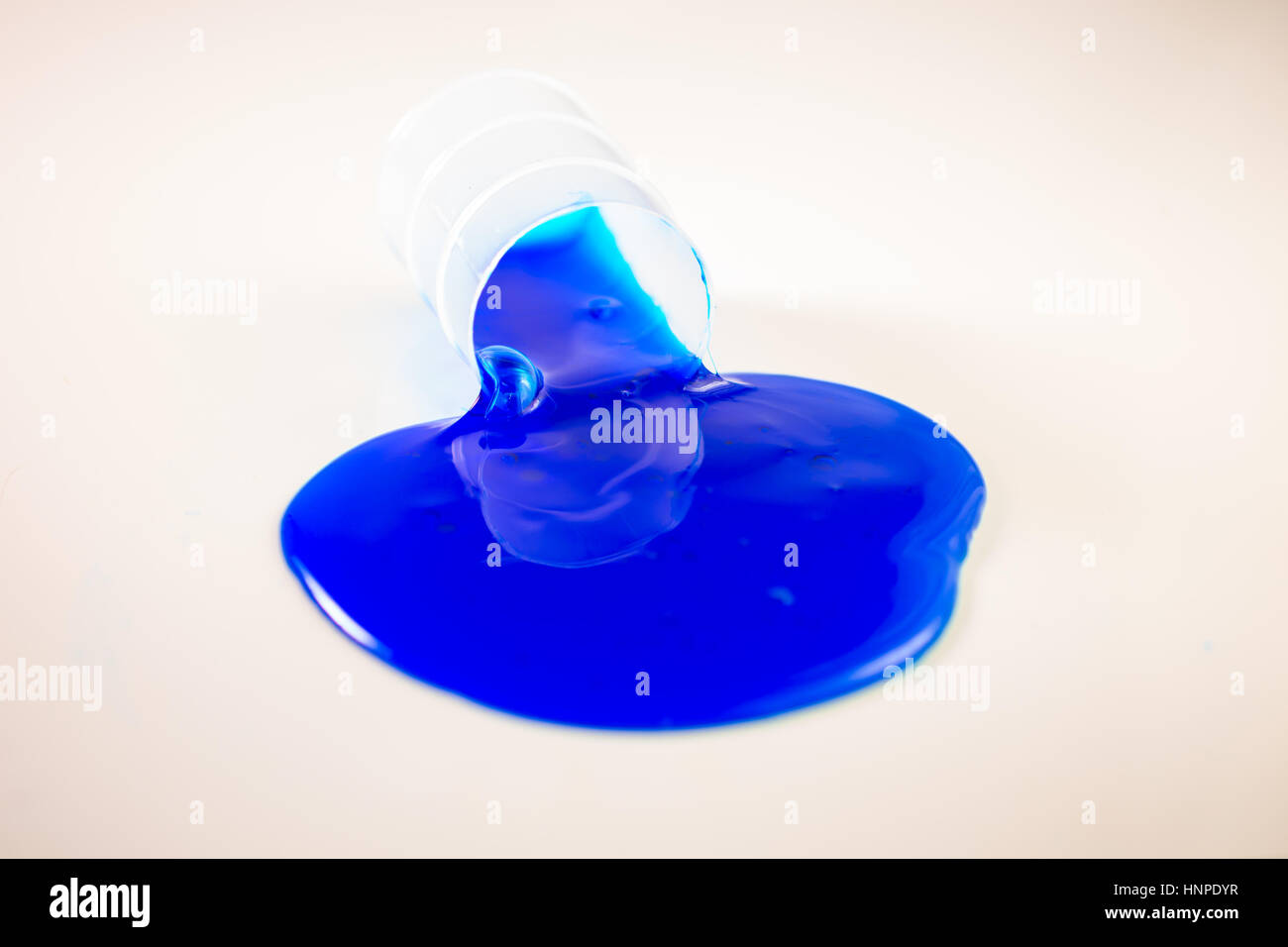 Blue slime spllling out of barrel on white background Stock Photo - Alamy