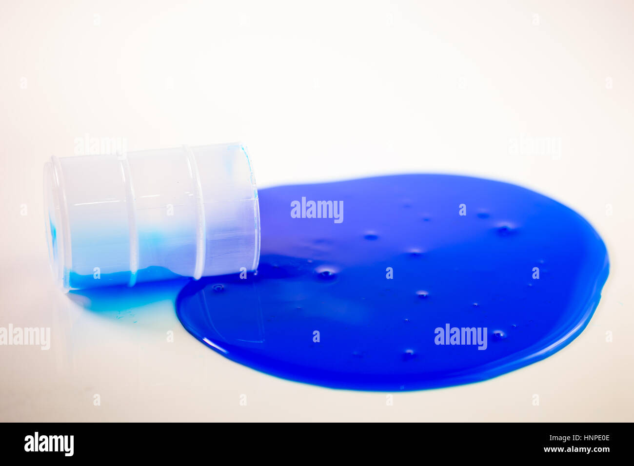 Blue slime spllling out of barrel on white background Stock Photo - Alamy