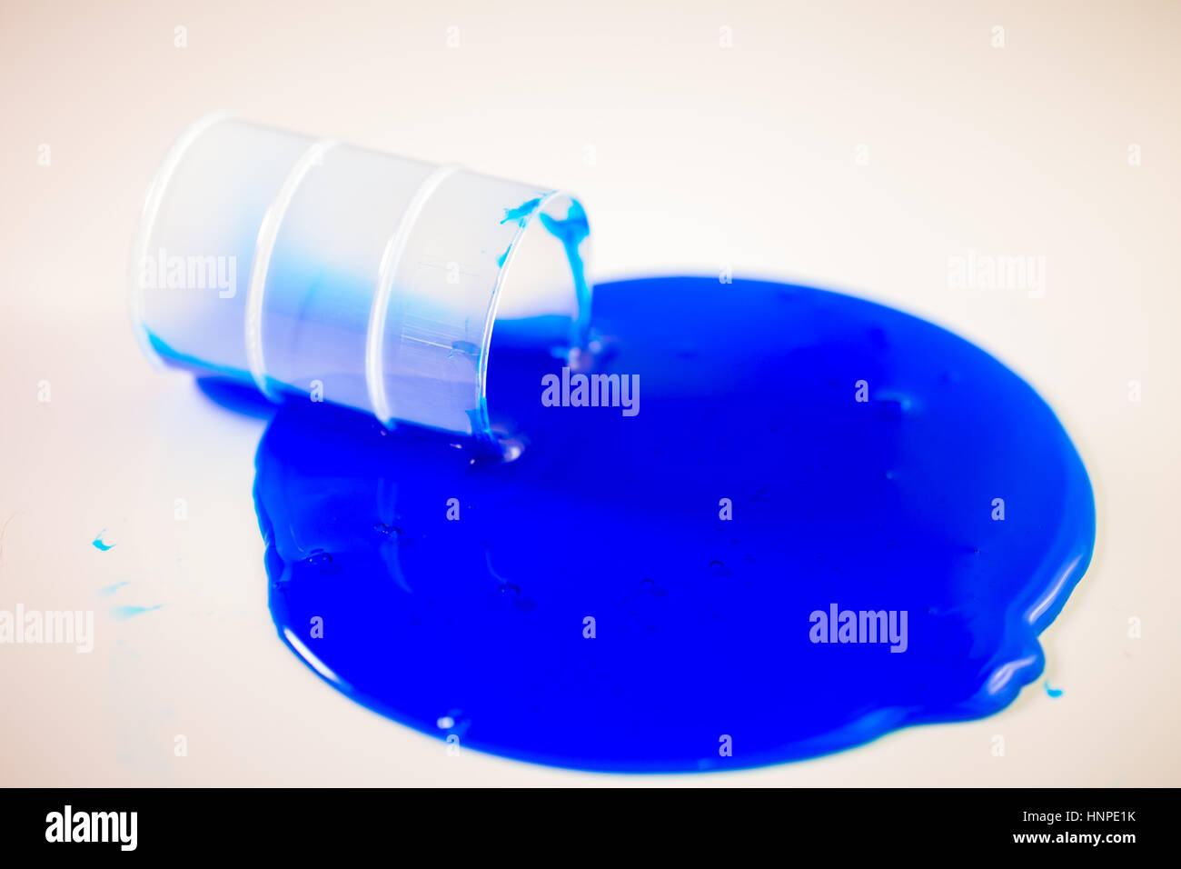 Blue slime spllling out of barrel on white background Stock Photo - Alamy
