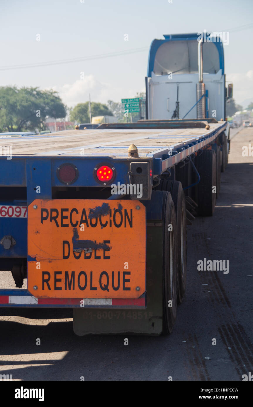 View from the back of a large truck, with a warning sign in ine of its ...