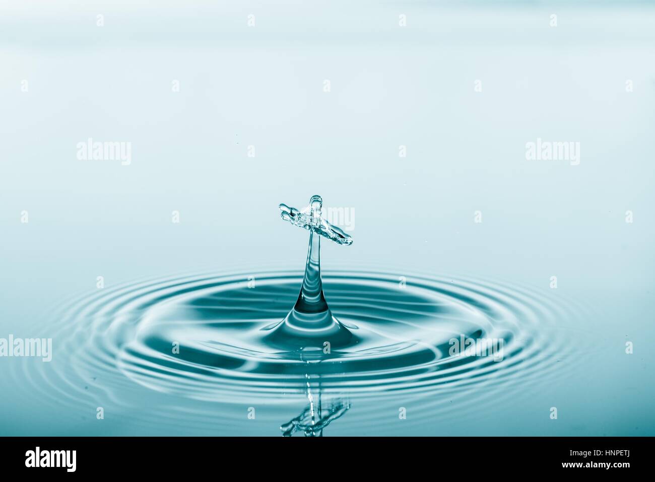 Water drop falling and drips on water mirror. Water drop splash and ...