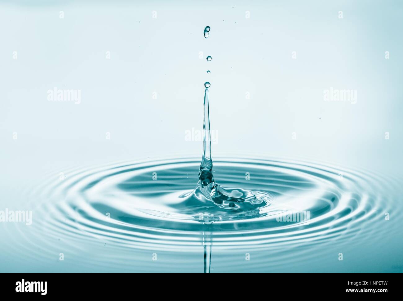 Water drop falling and drips on water mirror. Drops splash and make ...