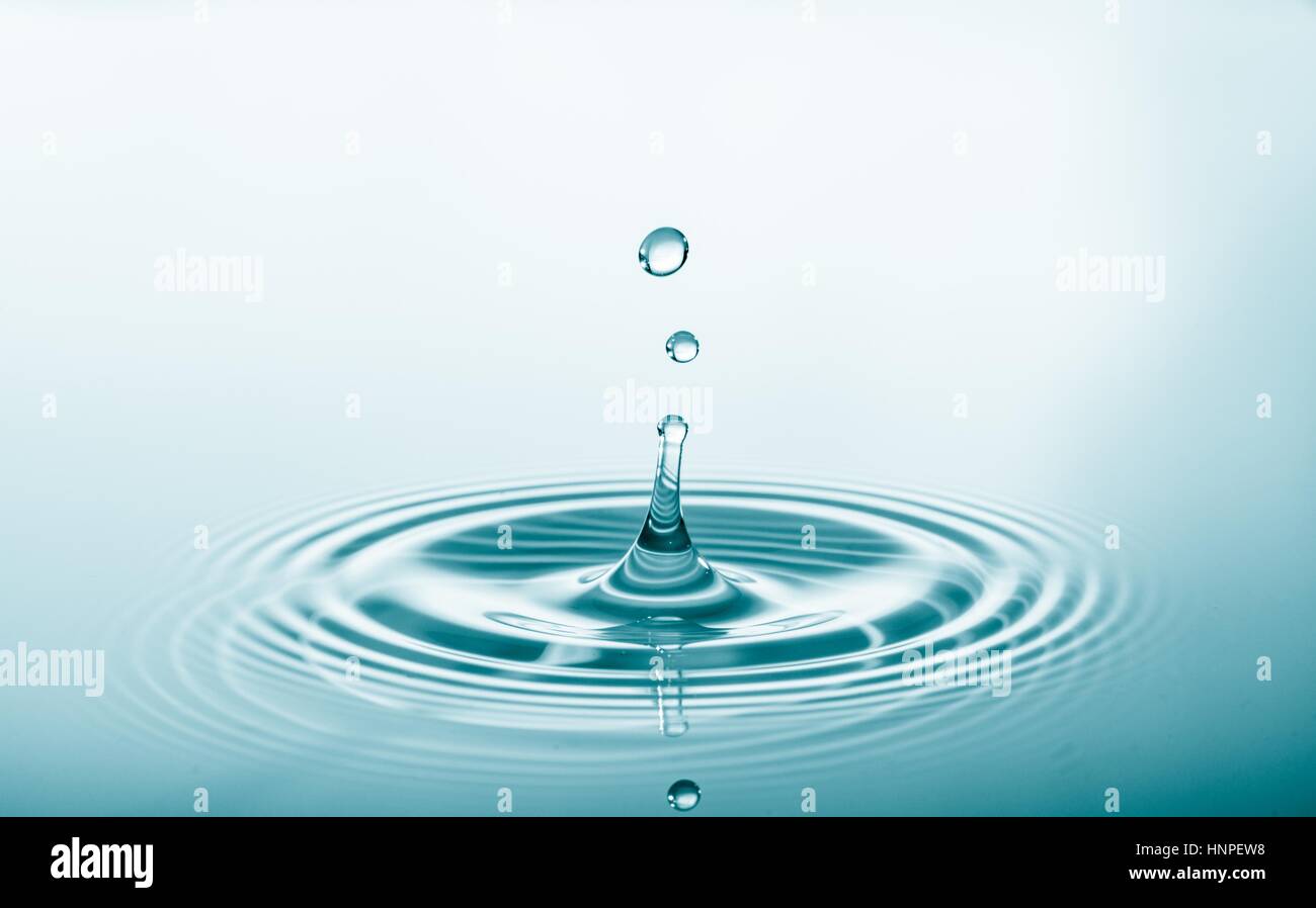 Water drop falling and drips on water mirror. Water drop splash and ...