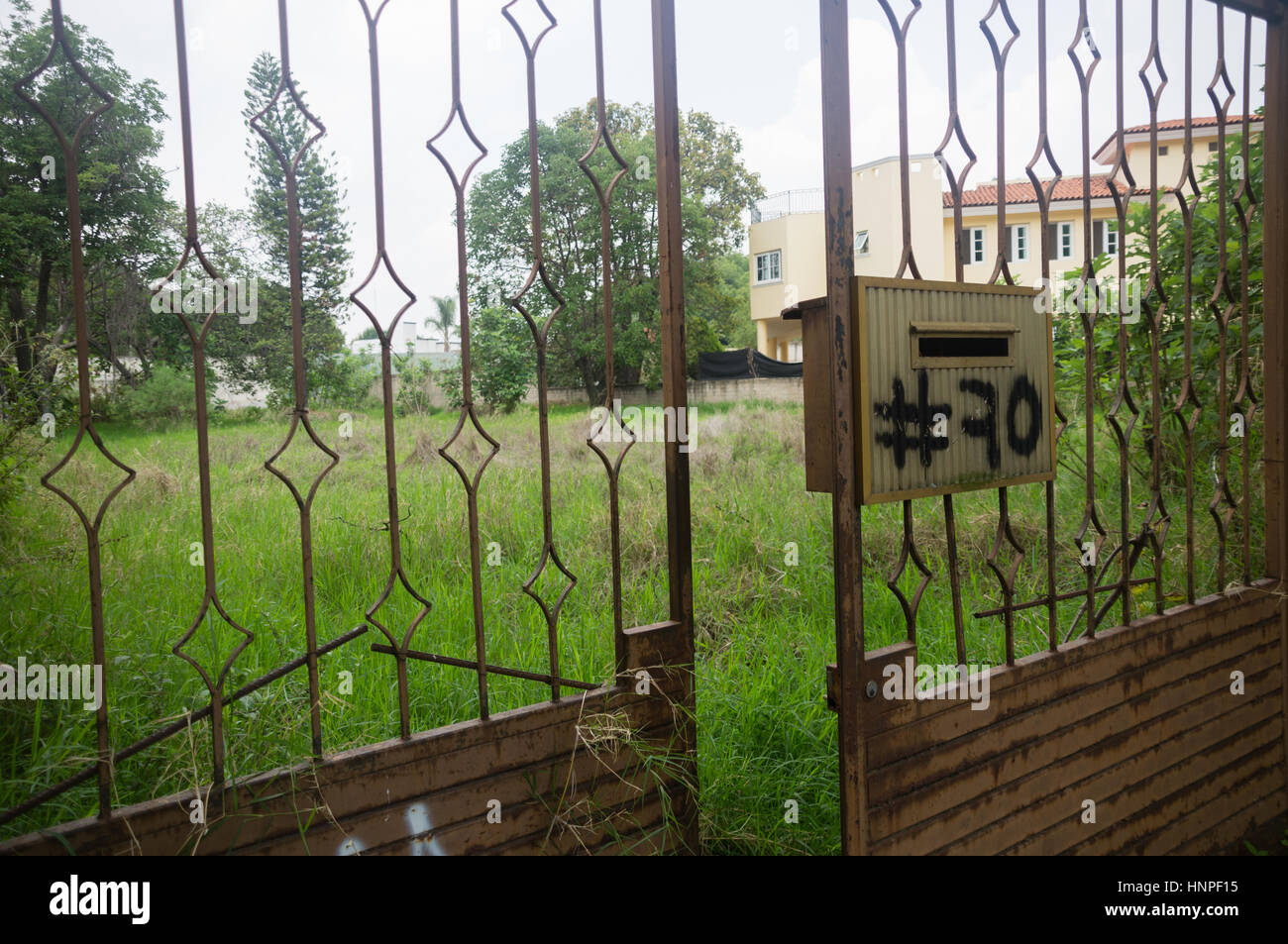 An open gate of an empty city lot Stock Photo - Alamy