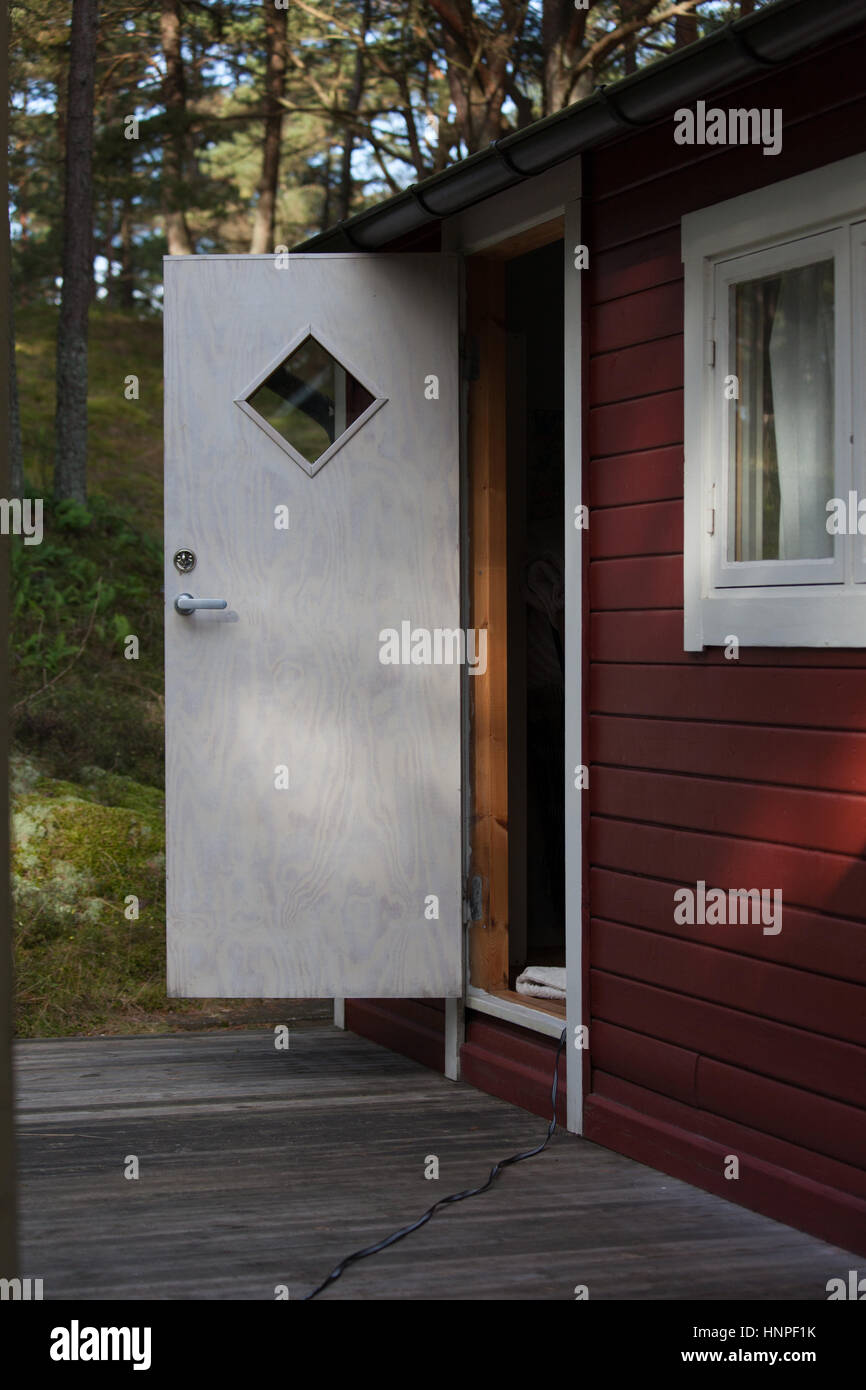 A cabin door, made of white wood, with a diamond window in it; opening ...