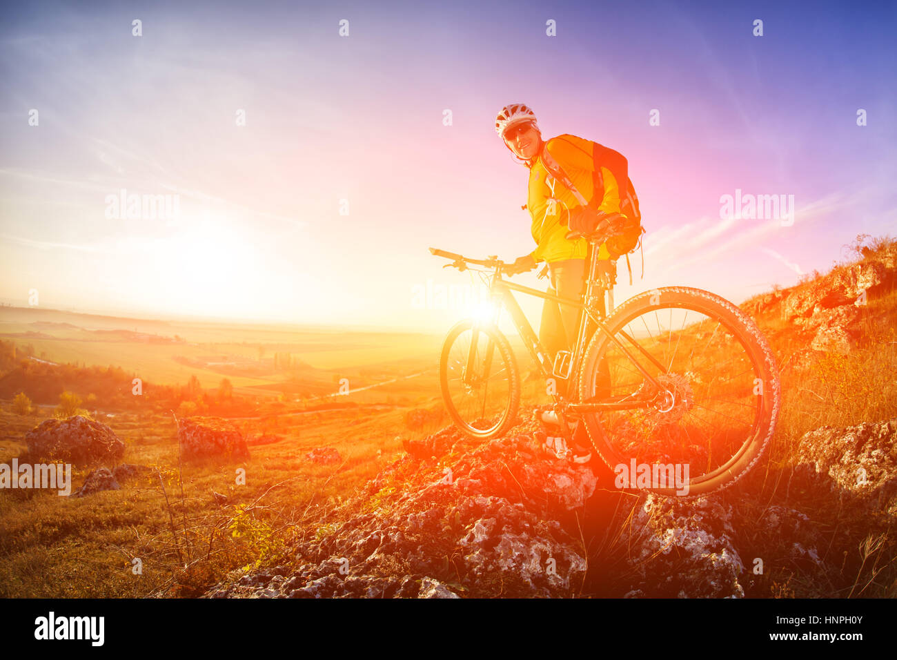 low angle view of cyclist standing with mountain bike on trail at ...