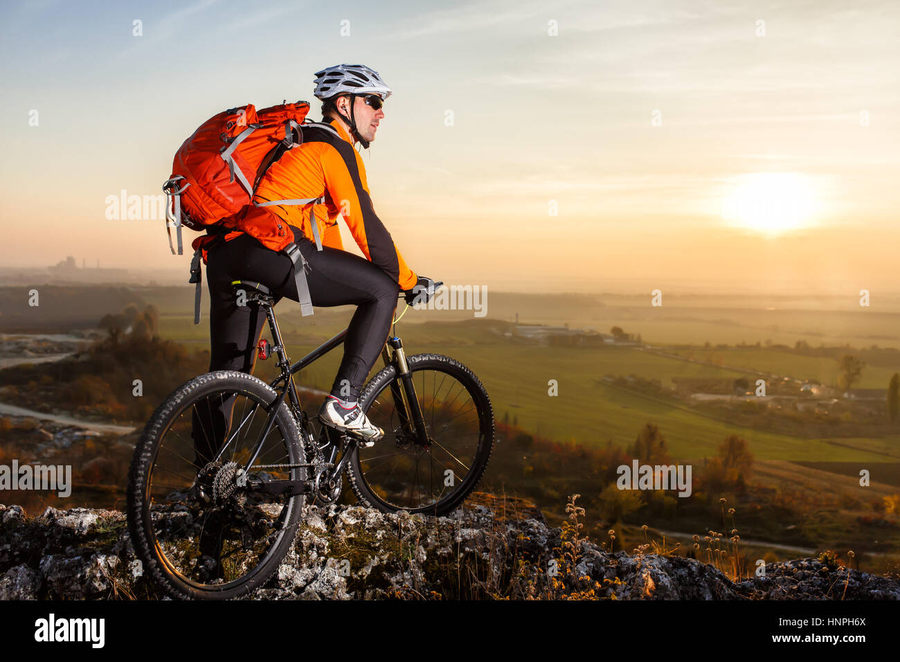 low angle view of cyclist standing with mountain bike on trail at ...
