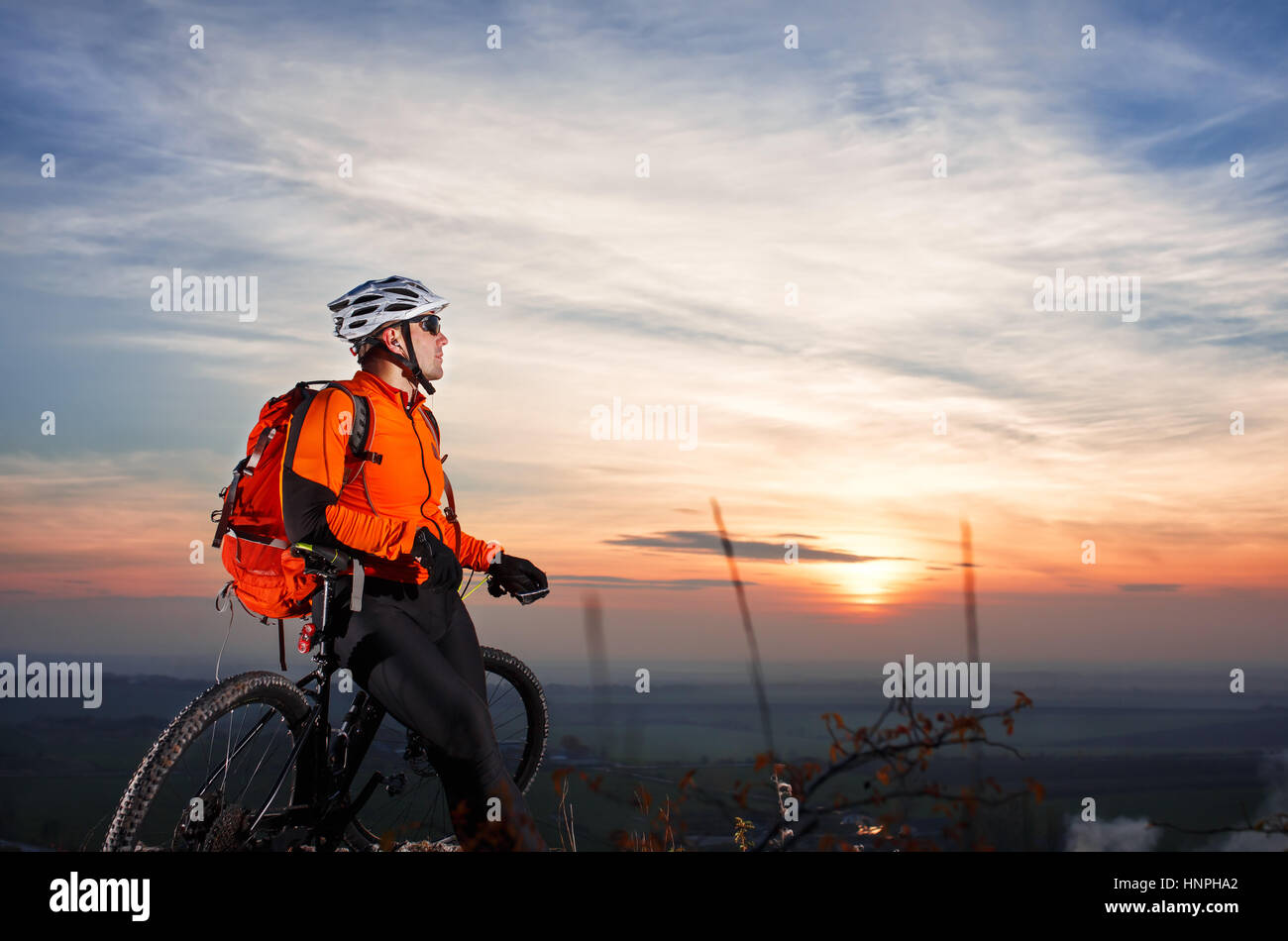 low angle view of cyclist standing with mountain bike on trail at ...