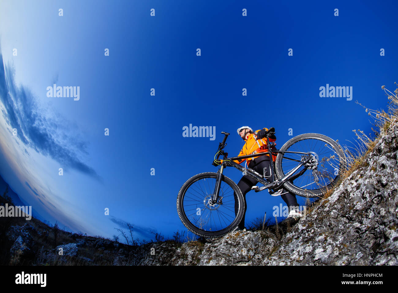 Cyclist Riding the Bike Down Hill on the Mountain Rocky Trail at Sunset ...