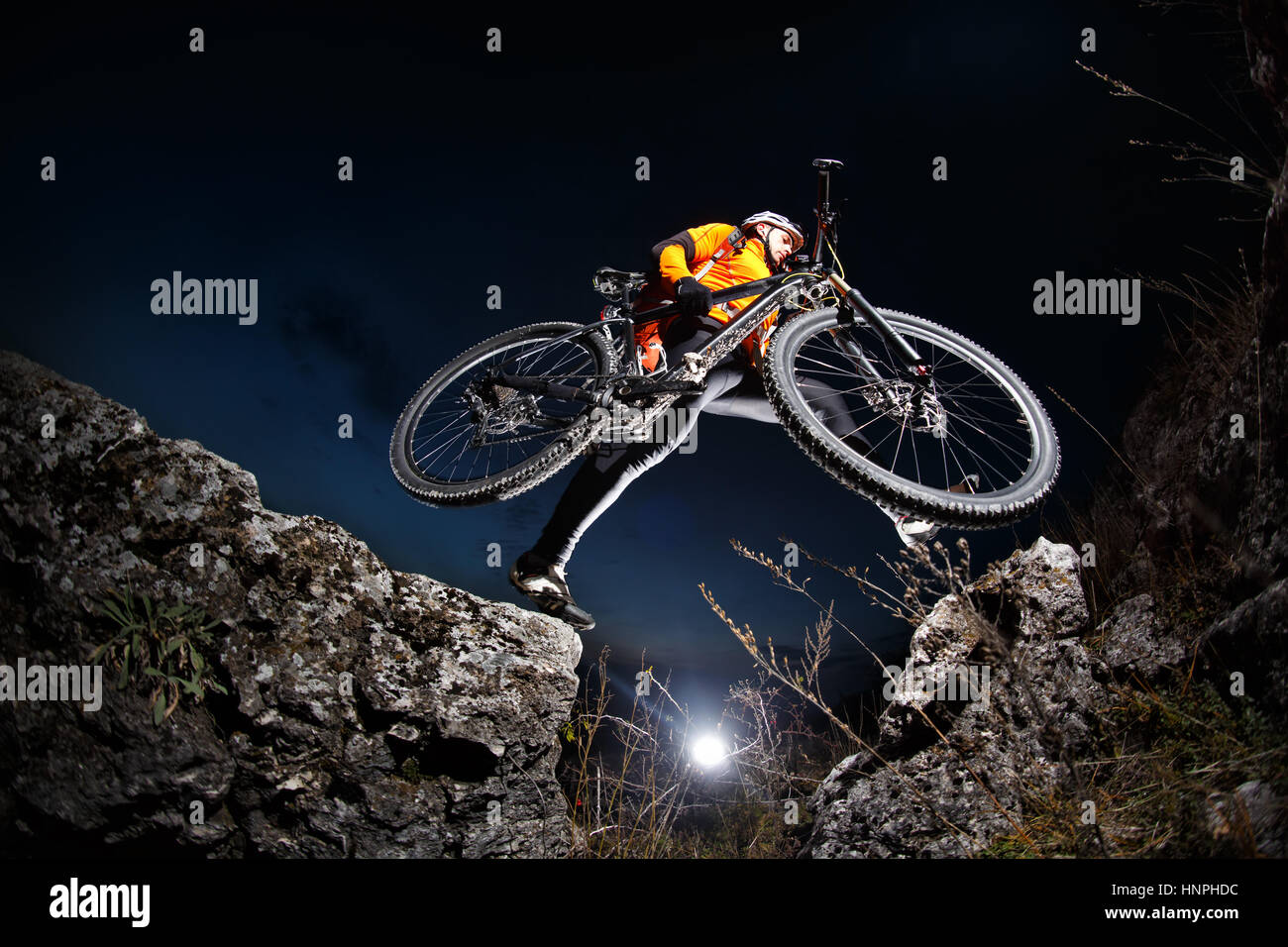 Cyclist Riding the Bike Down Hill on the Mountain Rocky Trail at Sunset ...