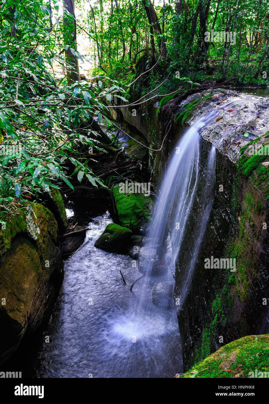 Small waterfall flows through the channel between the cliffs in the ...