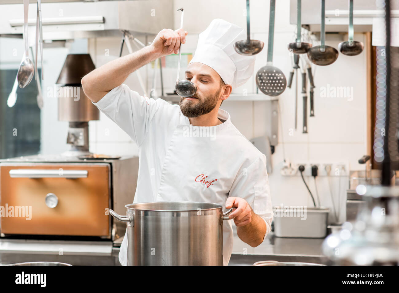 Chef cook tasting food with big scoop at the restaurant kitchen Stock ...