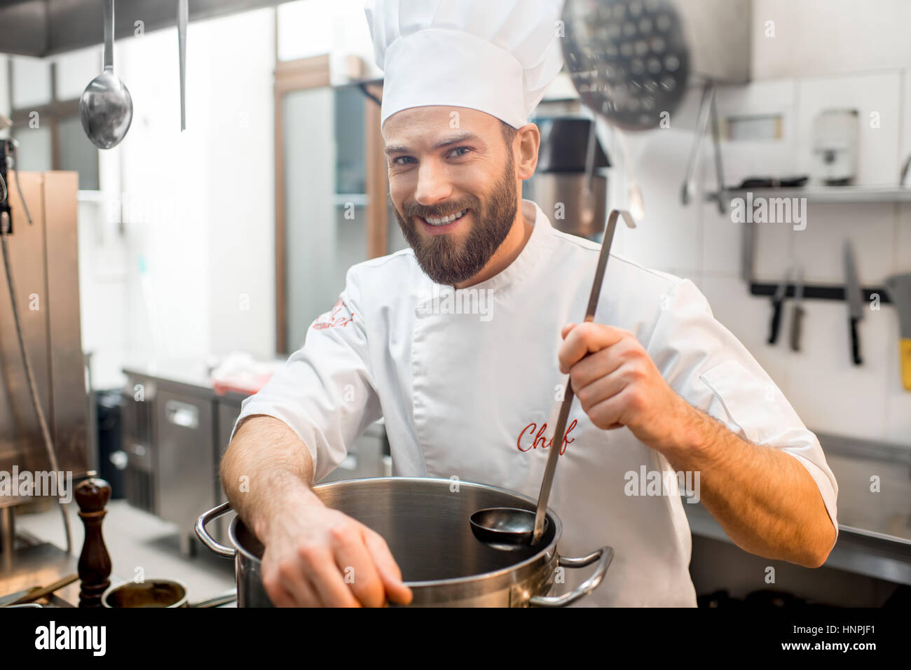 Portrait of a chef cook in uniform with big cooker at the restaurant ...