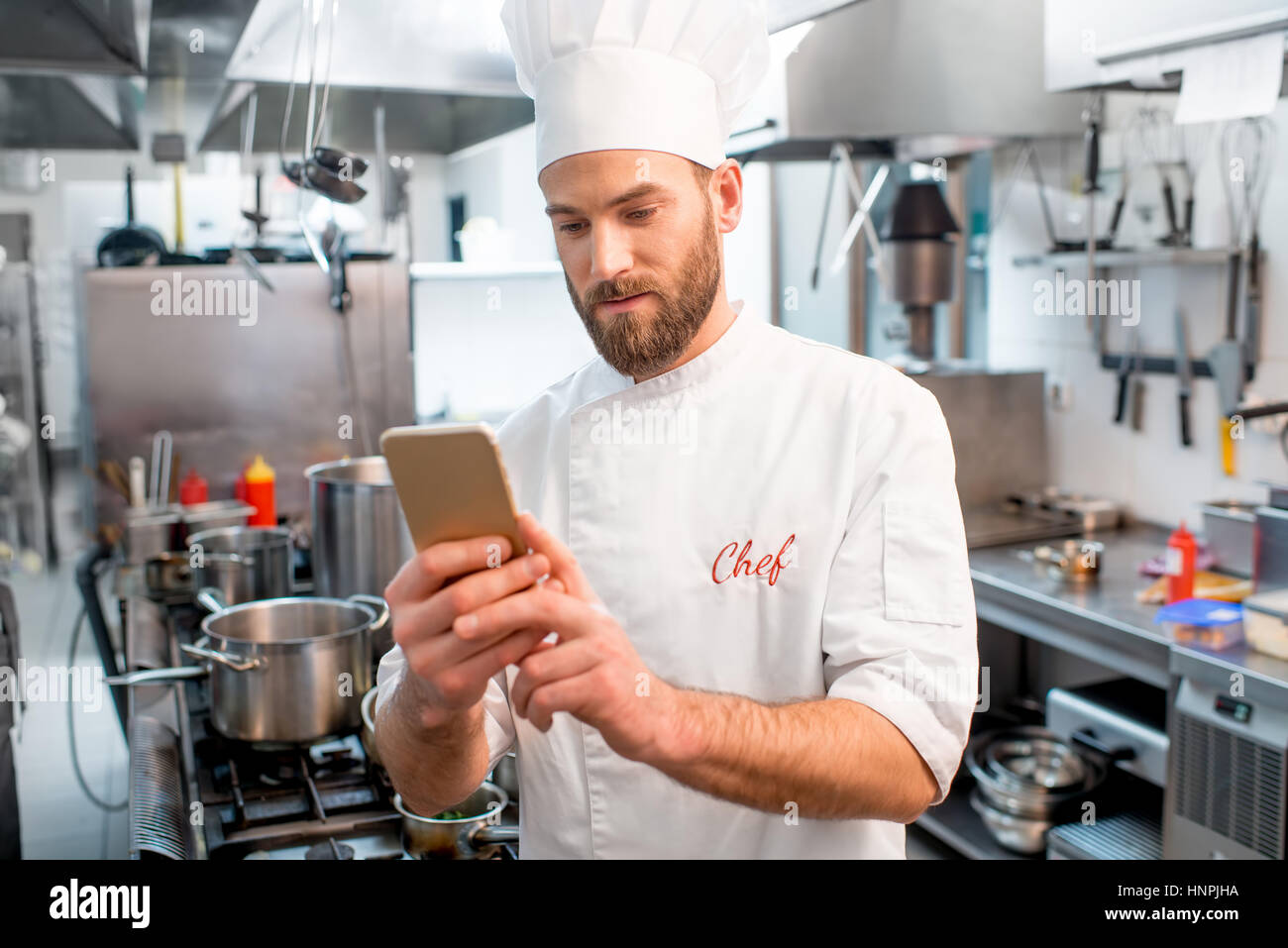 Chef cook using smart phone at the restaurant kitchen Stock Photo - Alamy