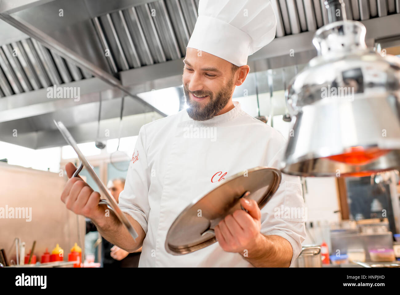 Chef cook holding pan covers at the restaurant kitchen Stock Photo - Alamy