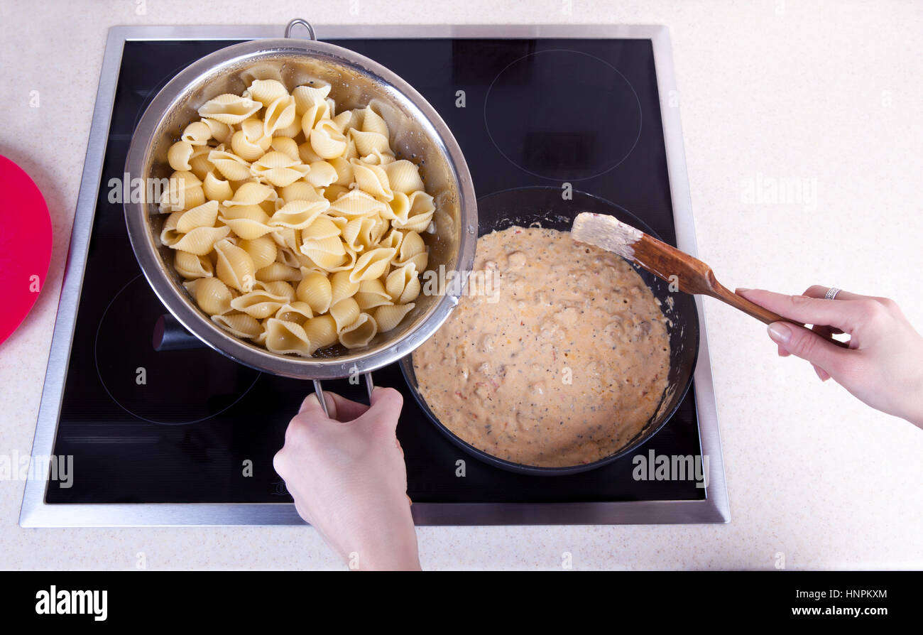Girl is preparing pasta with sauce on the induction cooker Stock Photo ...