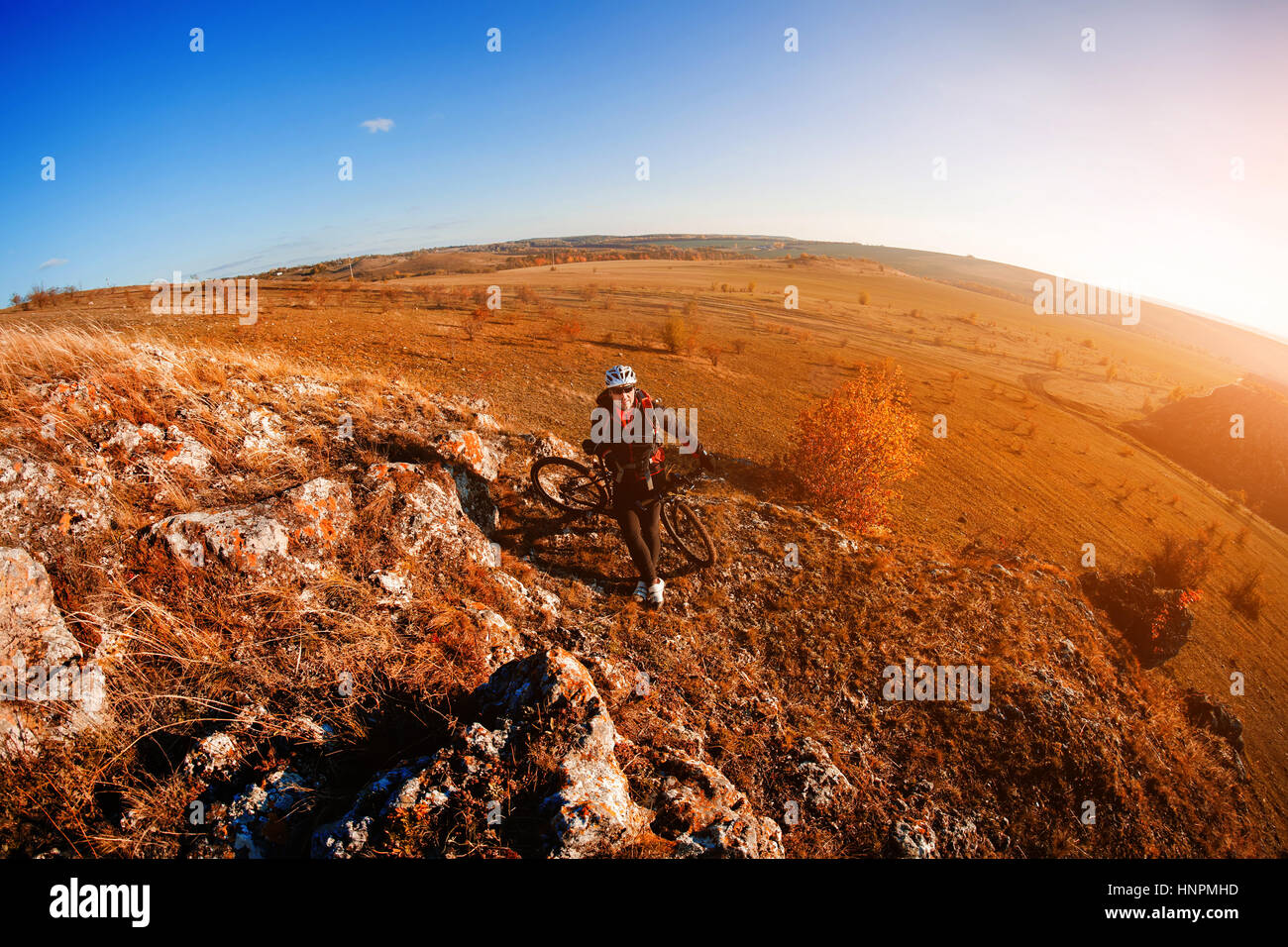 Wide angle view of cyclist standing with mountain bike on trail at ...