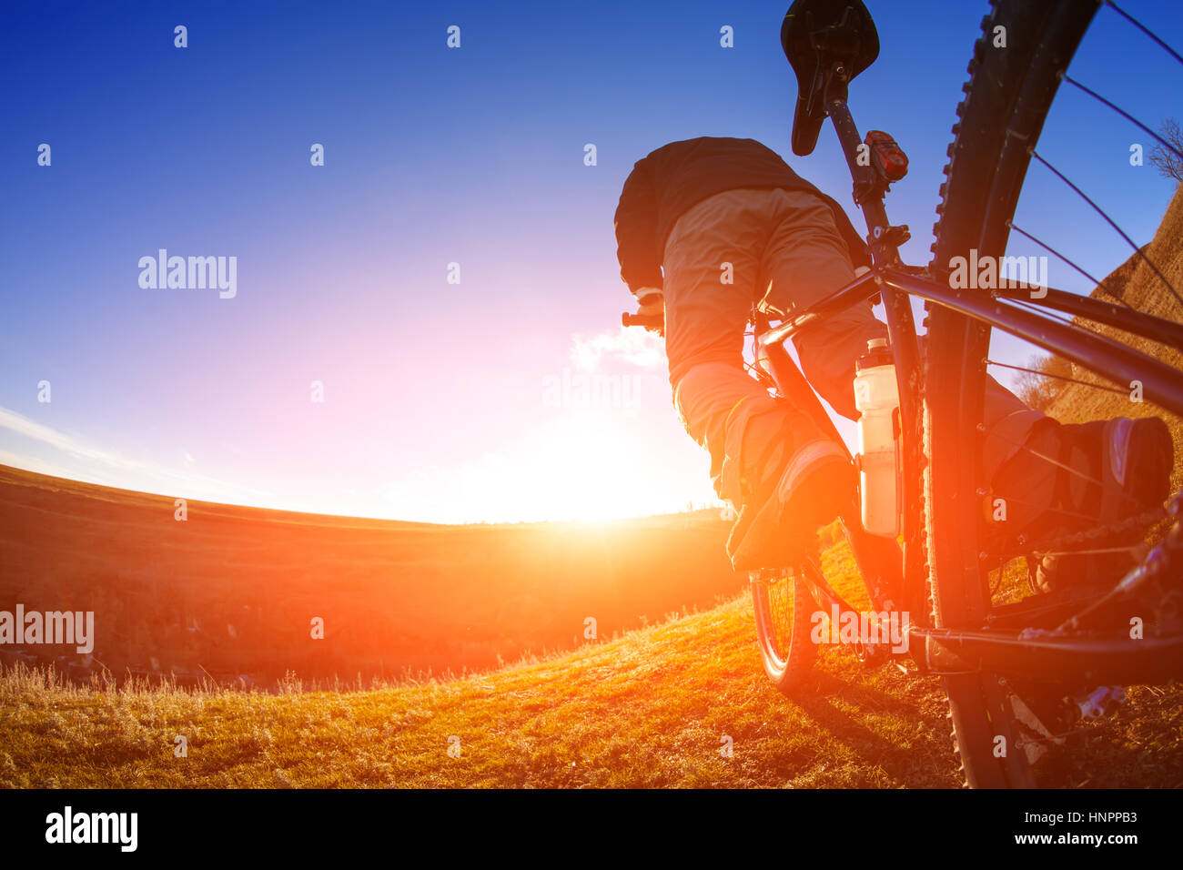 low angle view of cyclist standing with mountain bike on trail at ...