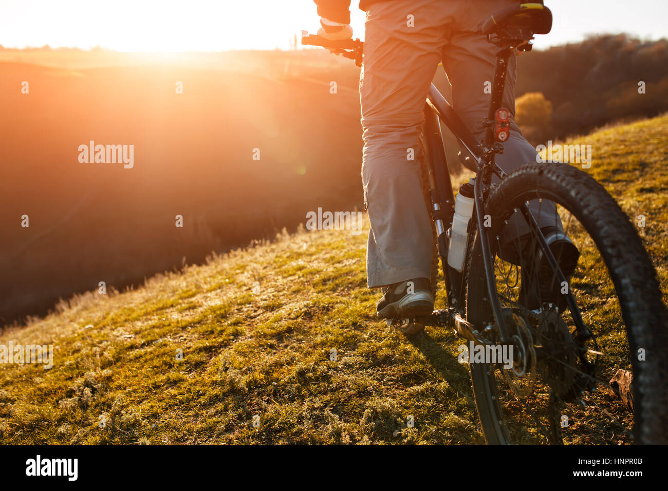 Close-up view on a cyclist on the hill. Biker riding a bike on the way ...