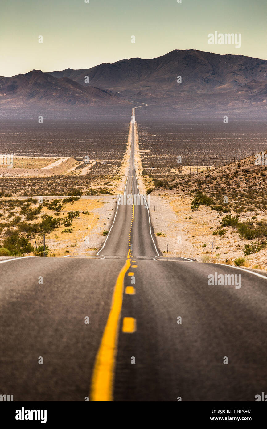 Classic vertical view of an endless straight road running through the ...