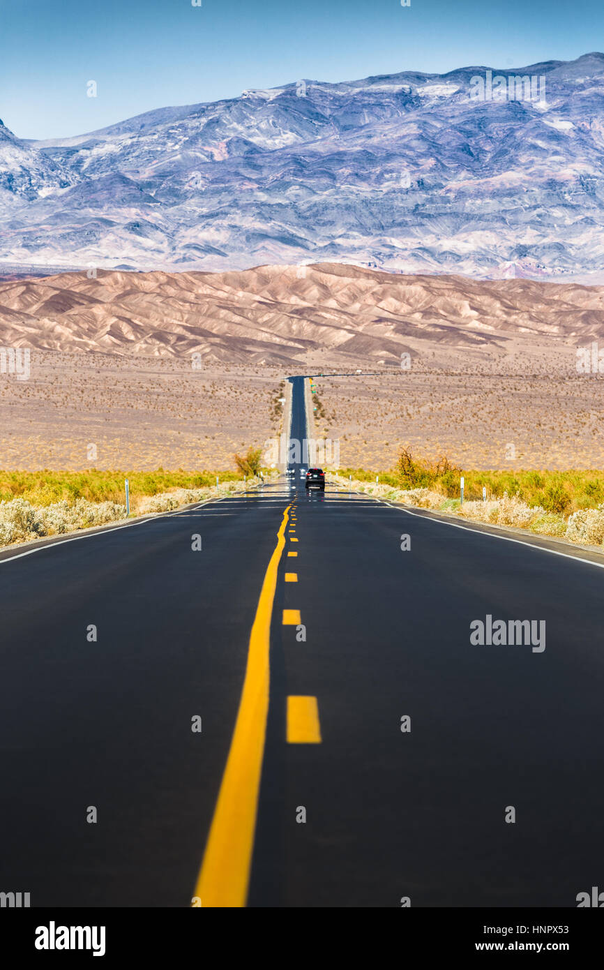 Classic vertical view of an endless straight road running through the ...