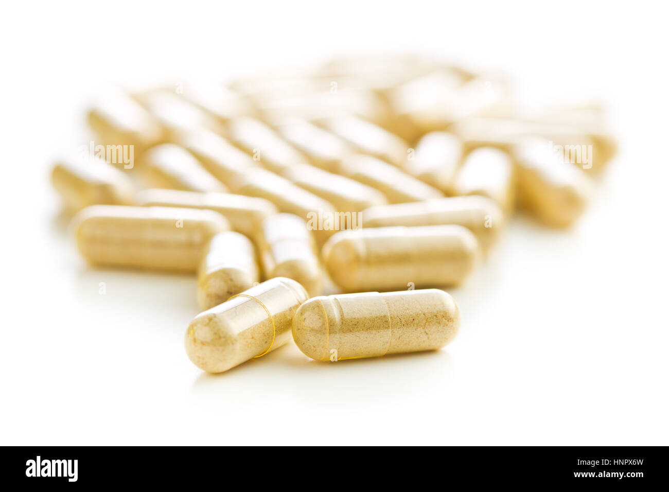 The yellow capsules isolated on white background Stock Photo - Alamy