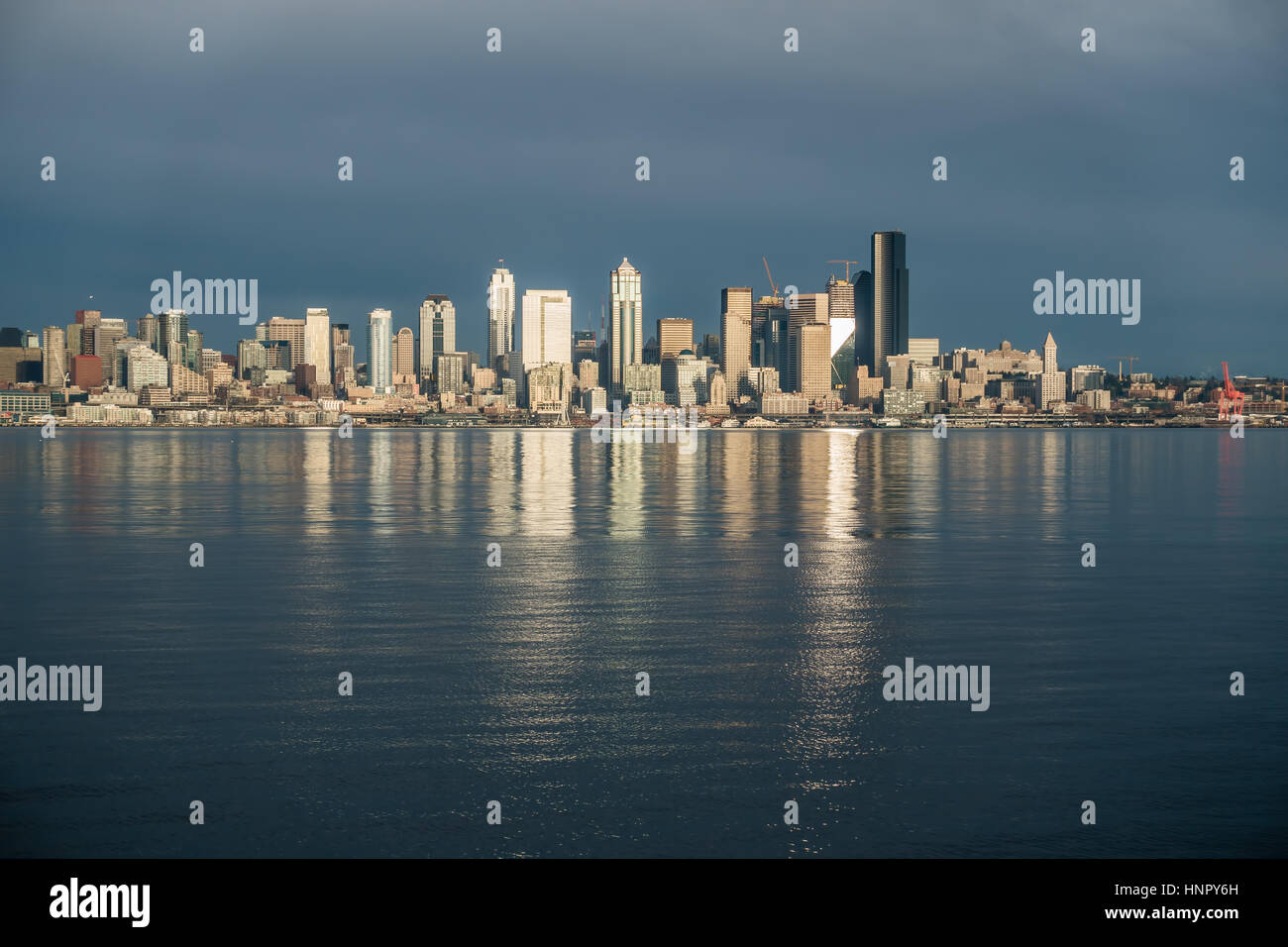 As the sun sets the buildings of the Seattle skyline are reflected in ...