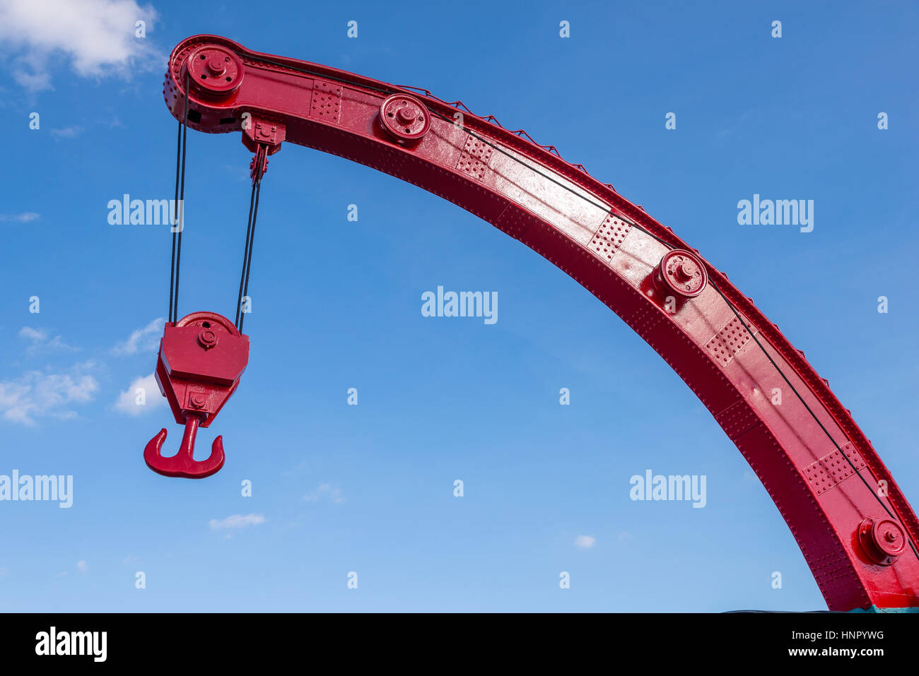 A red industrial hook suspended by two wires at the end of a boom Stock ...