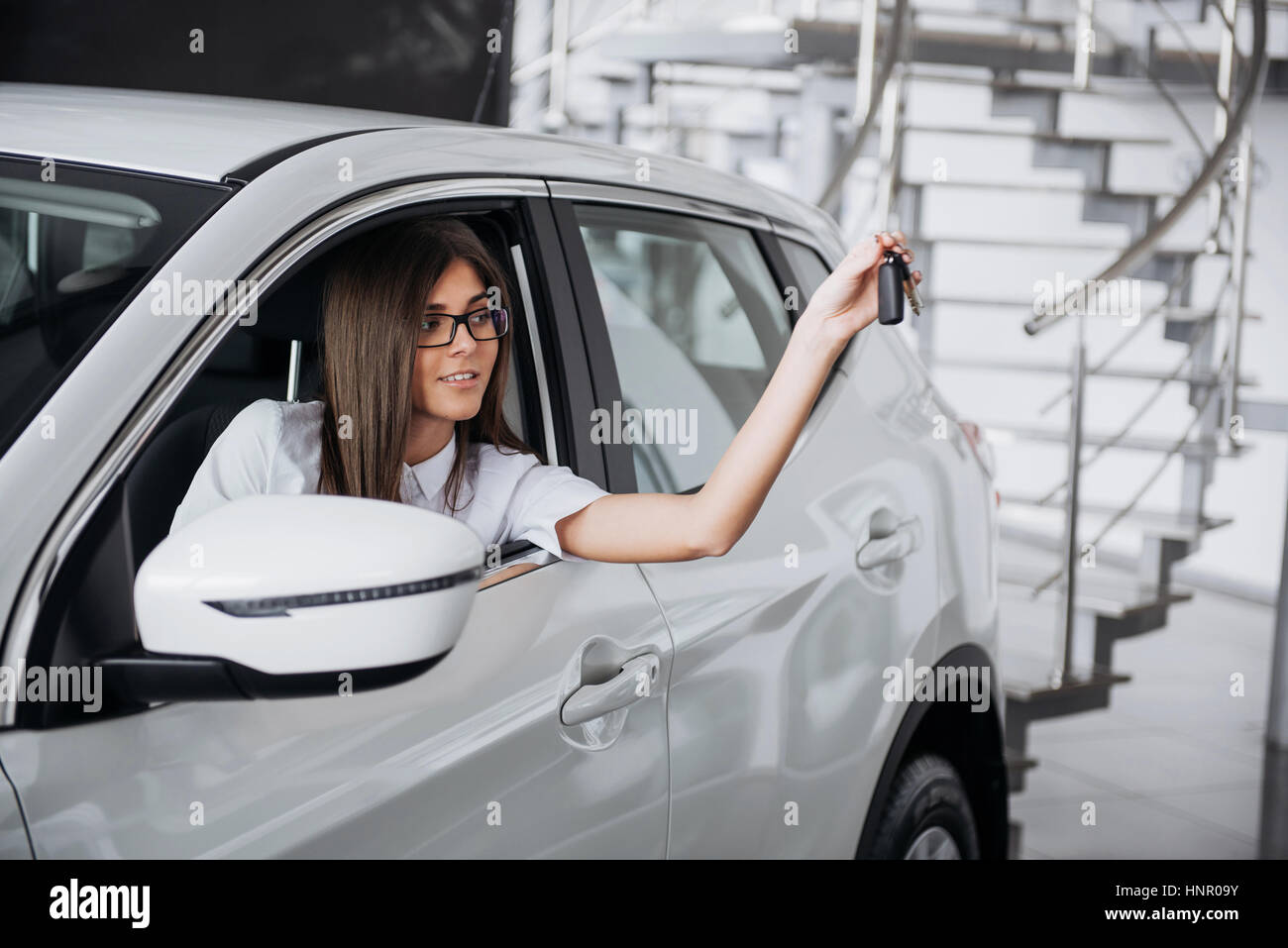 The woman driver smiling showing new car keys Stock Photo - Alamy