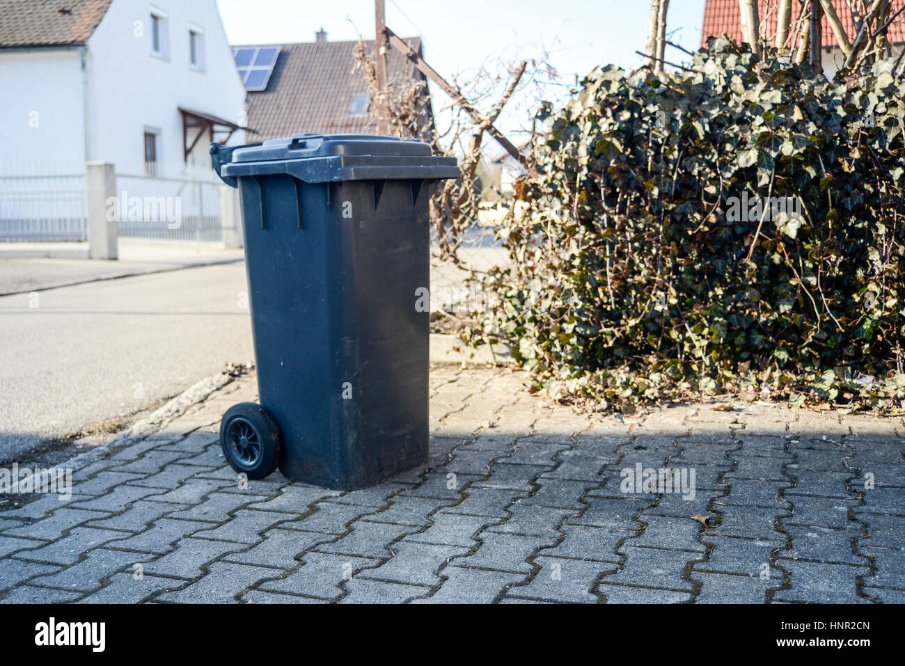 Garbage bin stands at the curb before being emptied Stock Photo - Alamy