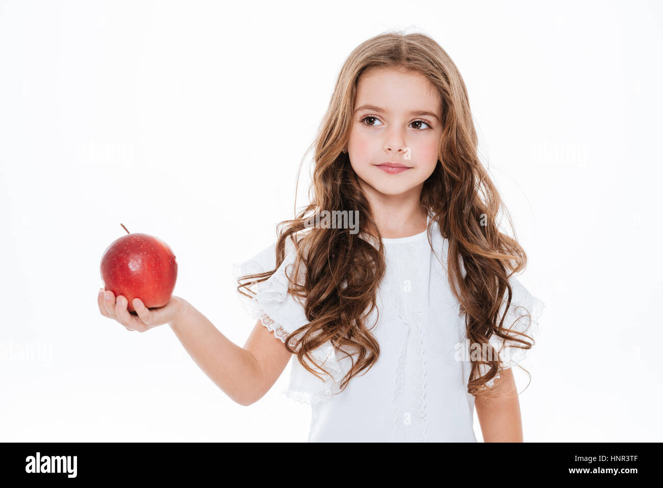 Portrait of beautiful curly little girl holding red apple over white ...