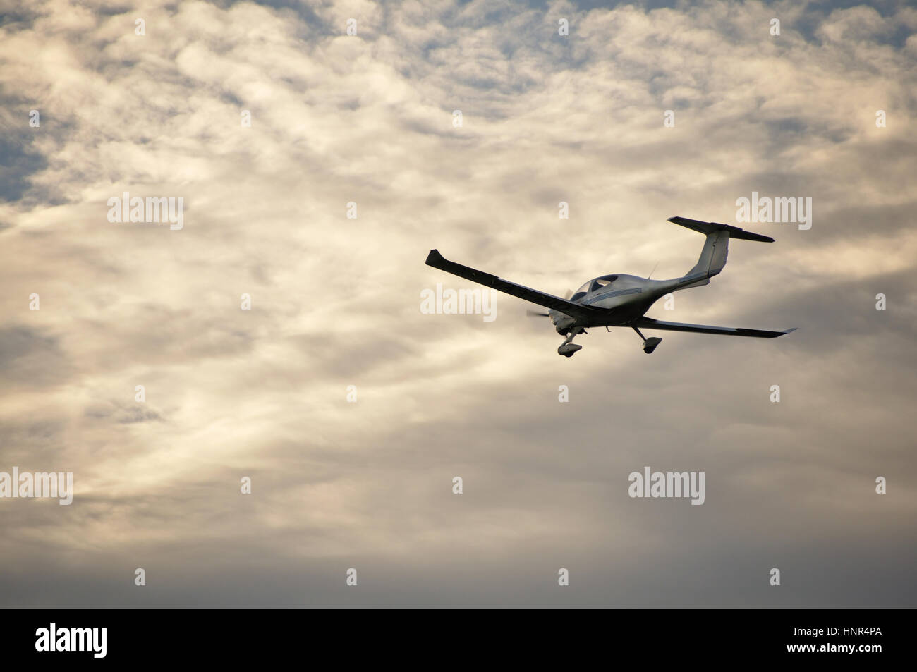 Small plane in the air. Blue sky with white clouds Stock Photo - Alamy