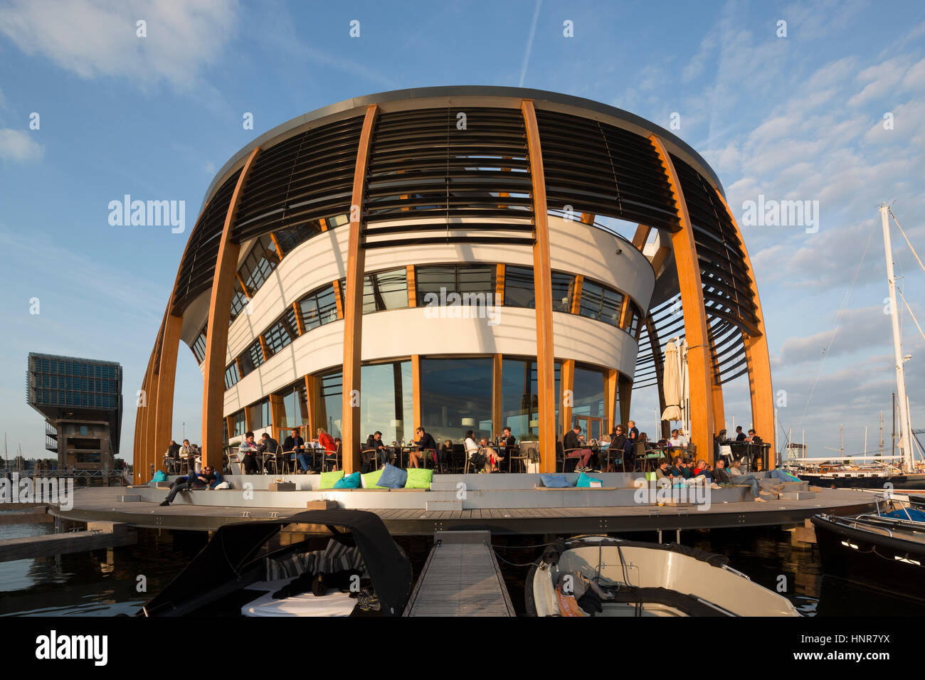 South facing part of building at sunset with busy terrace and boats ...
