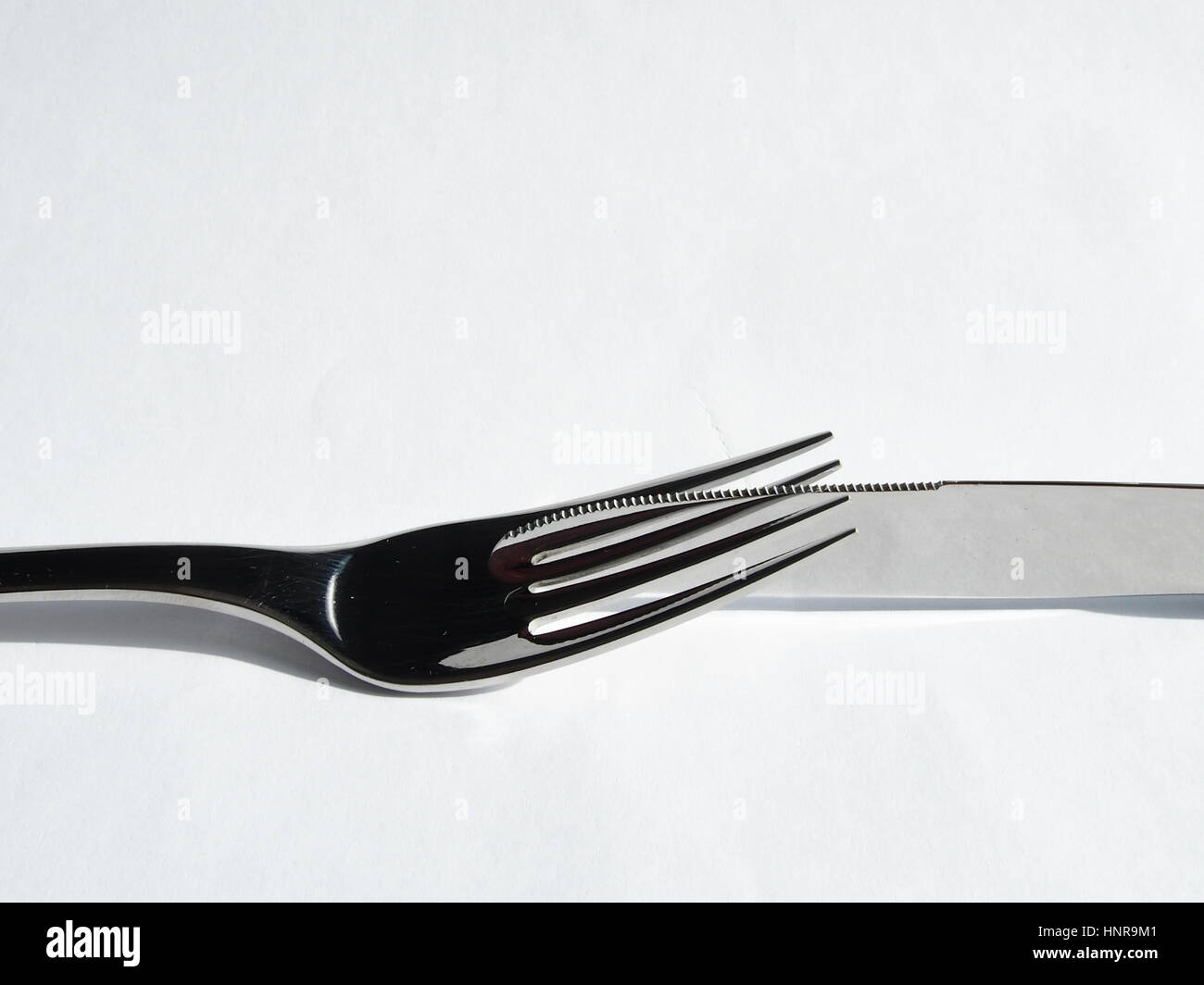 Knife and fork reflection on white background Stock Photo - Alamy