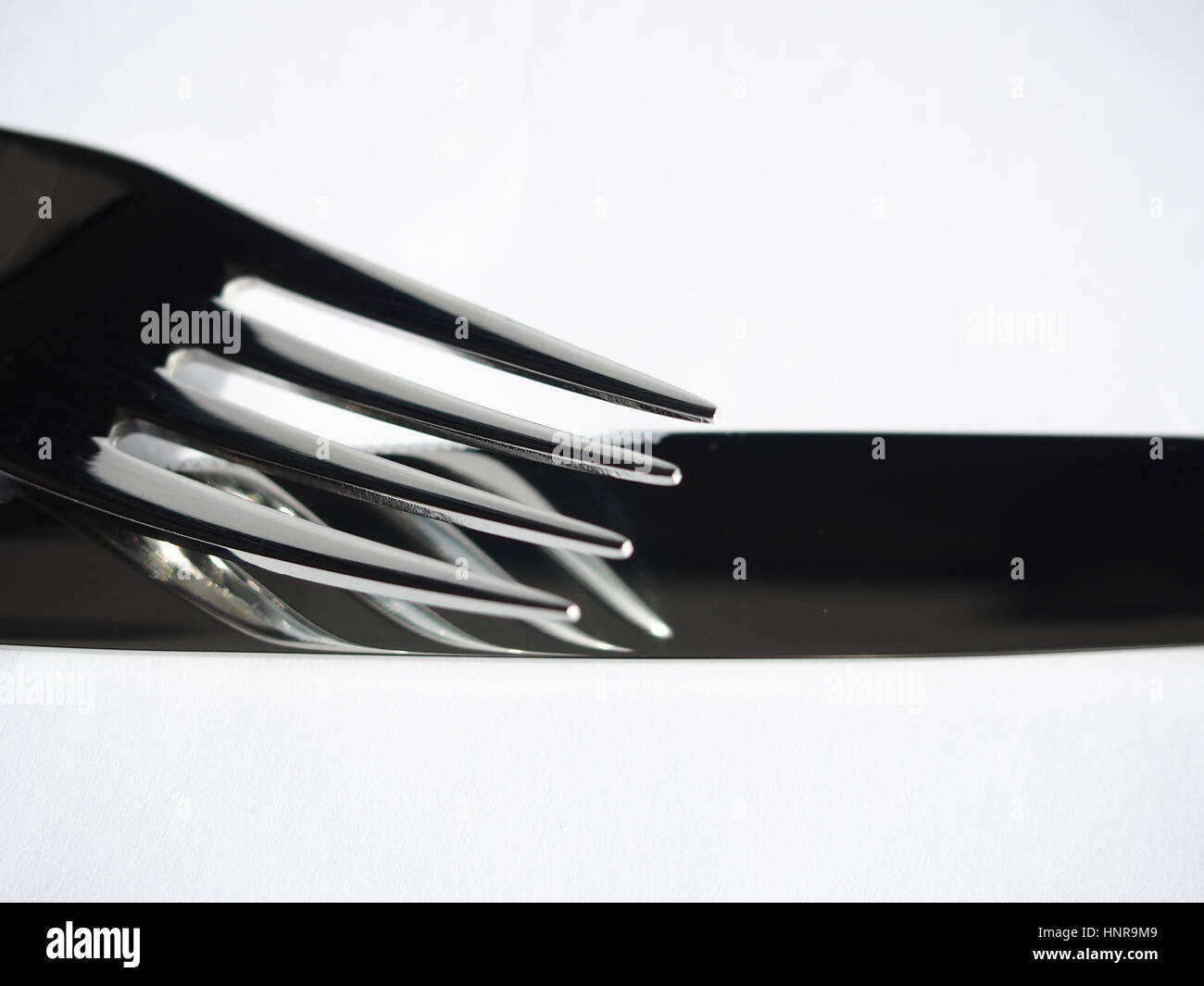 Knife and fork reflection on white background Stock Photo - Alamy