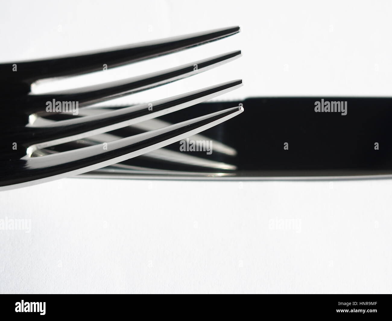Knife and fork reflection on white background Stock Photo - Alamy