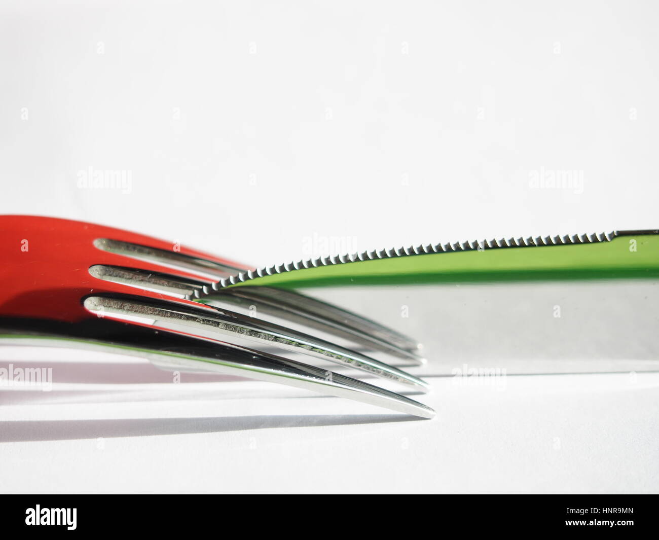 Knife and fork reflection on white background Stock Photo - Alamy